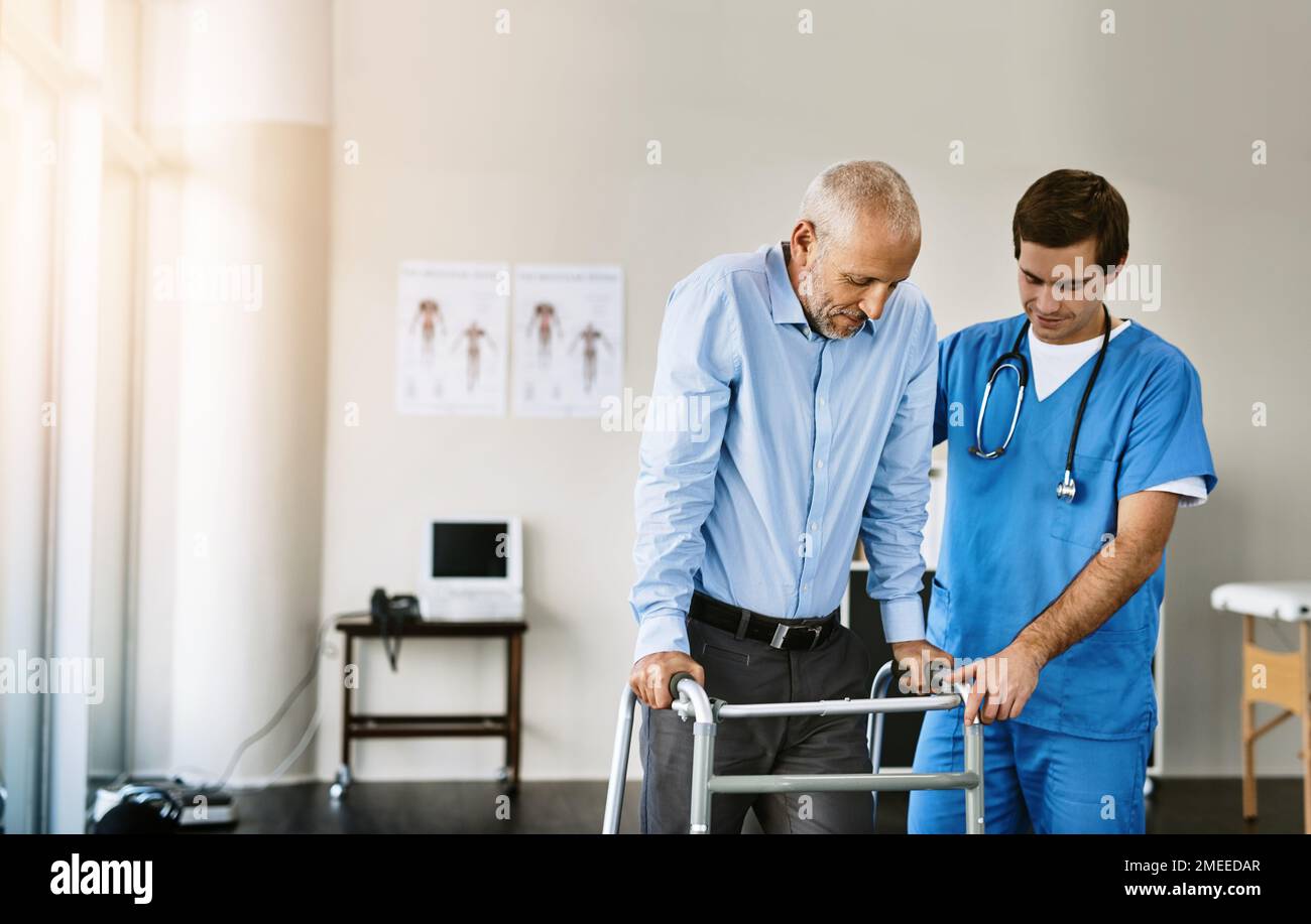 Taking the first step towards recovery. a male nurse assisting a senior ...
