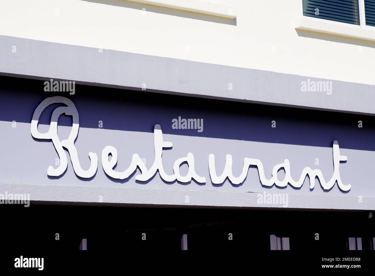 restaurant text sign on grey facade building city street storefront ...