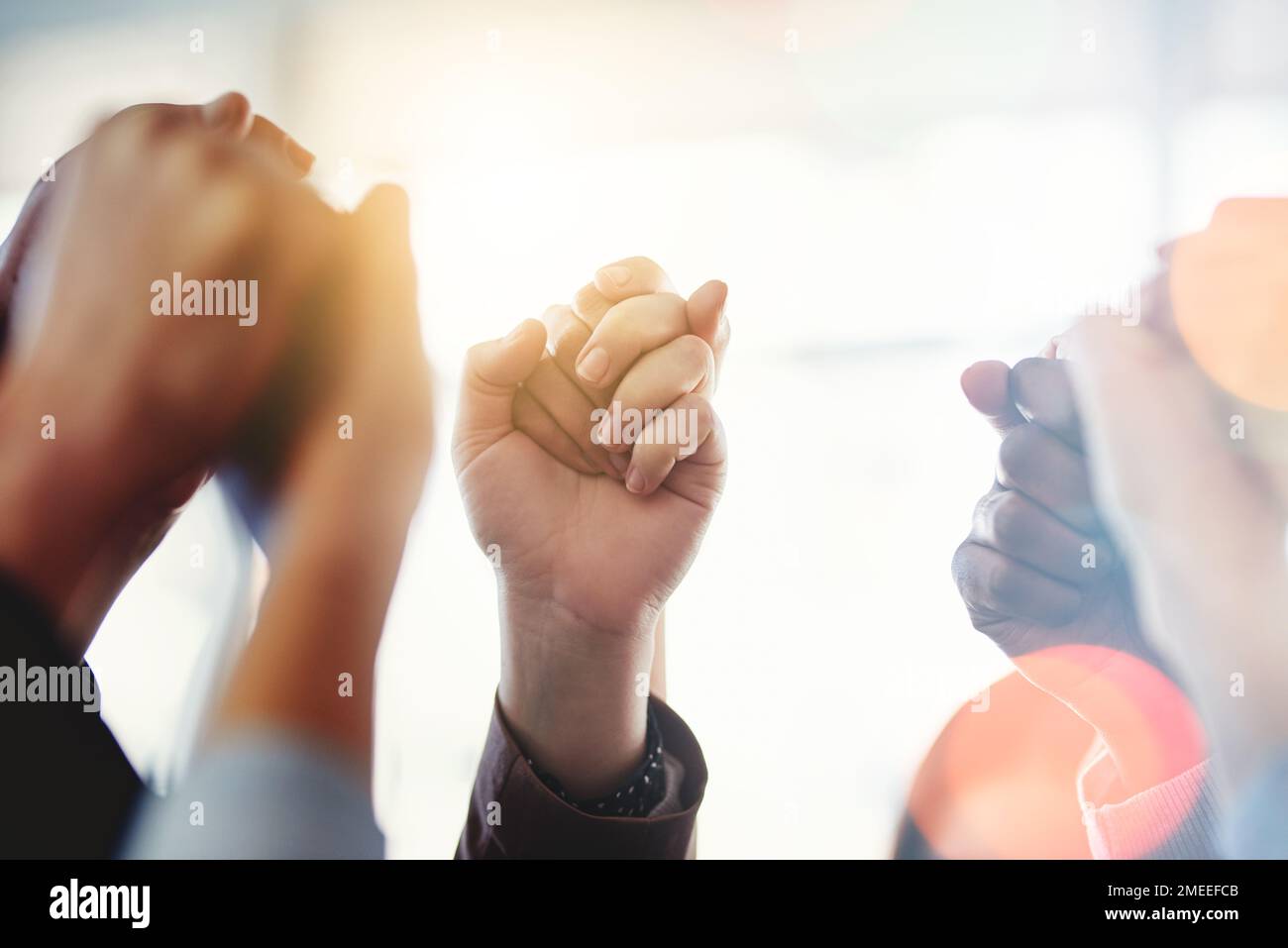 We support each other. a group of unrecognizable businesspeople holding ...