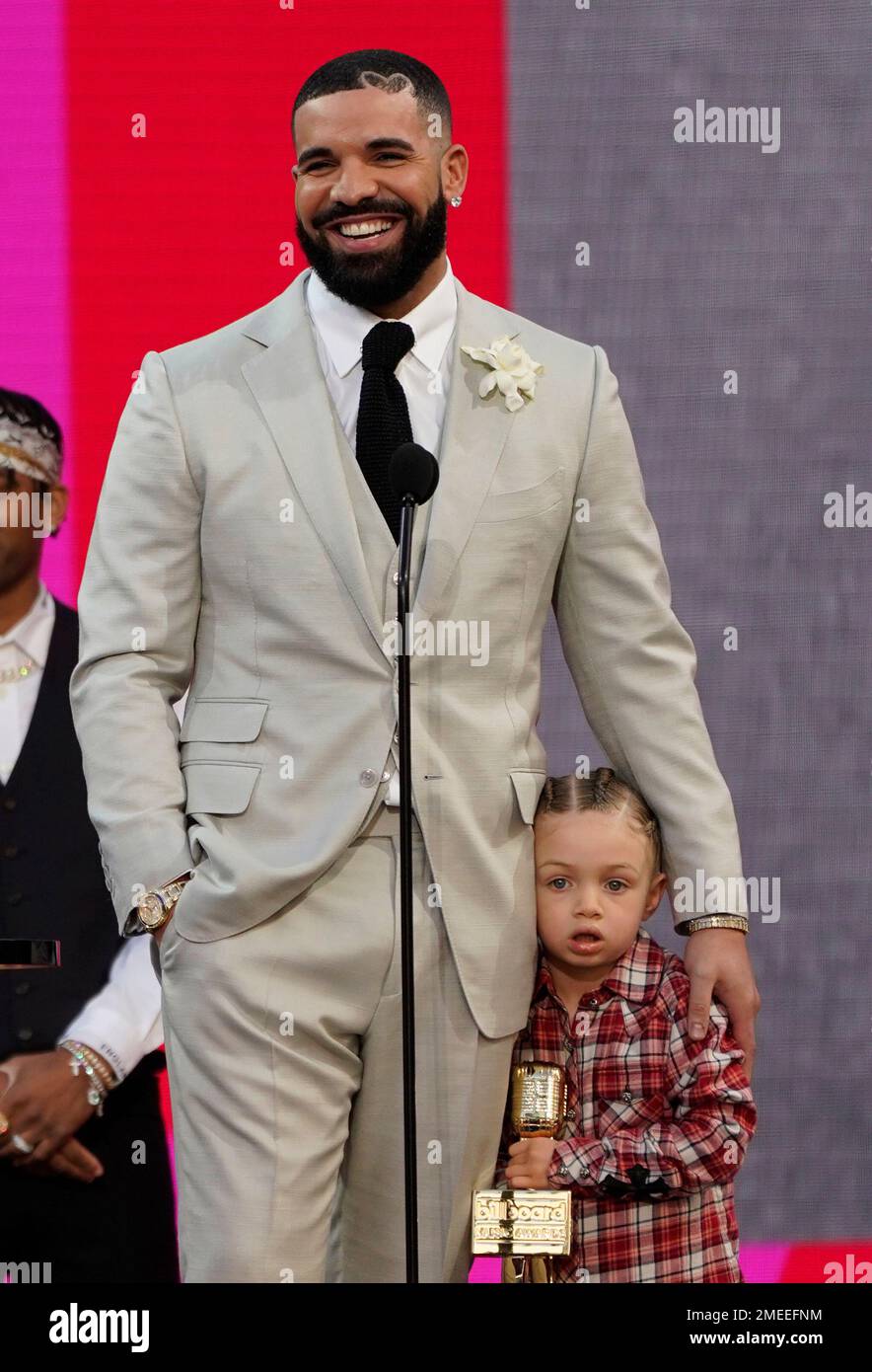Drake accepts the artist of the decade award as he holds his son Adonis ...