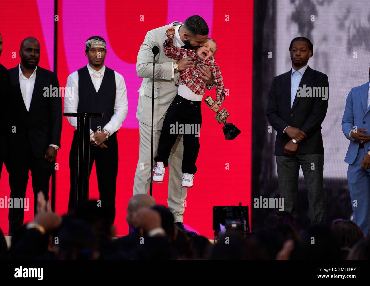 Drake carries his son Adonis Graham as he accepts the artist of the ...