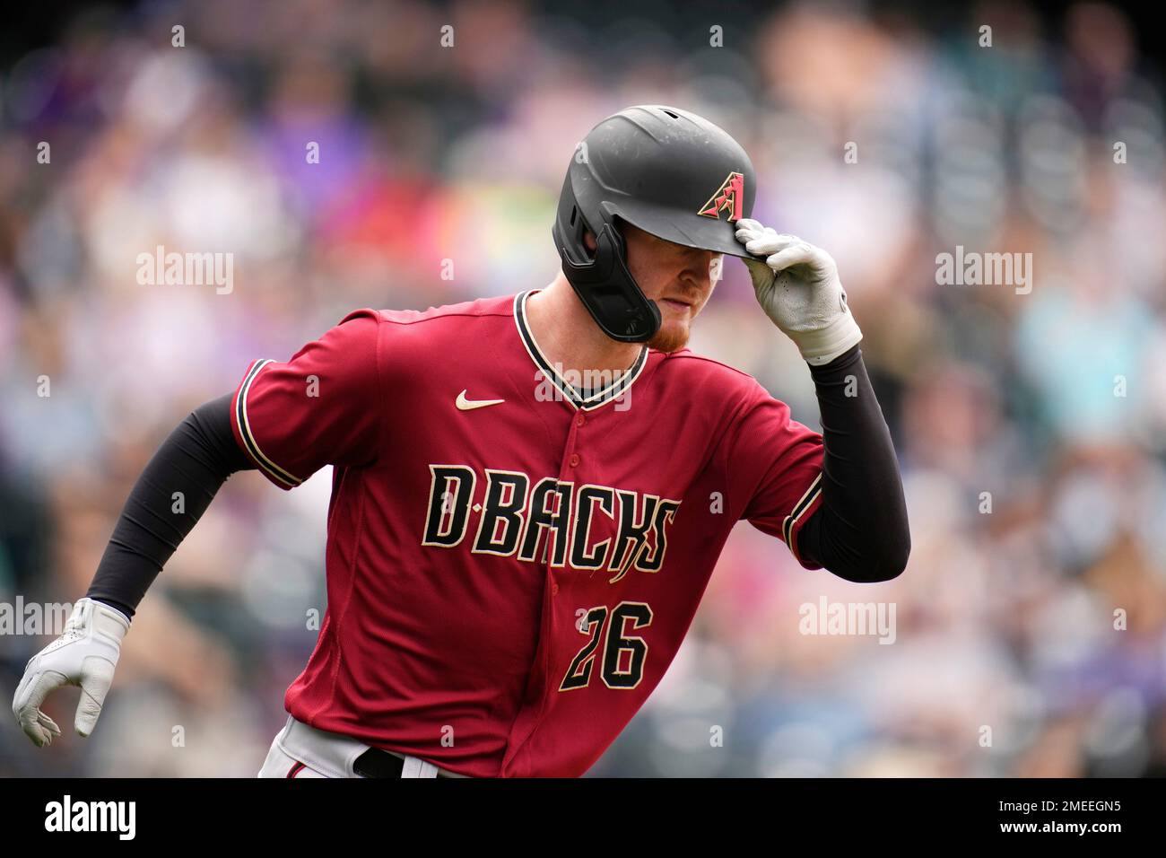 Arizona Diamondbacks' Pavin Smith holds on to the bill of his helmet as ...