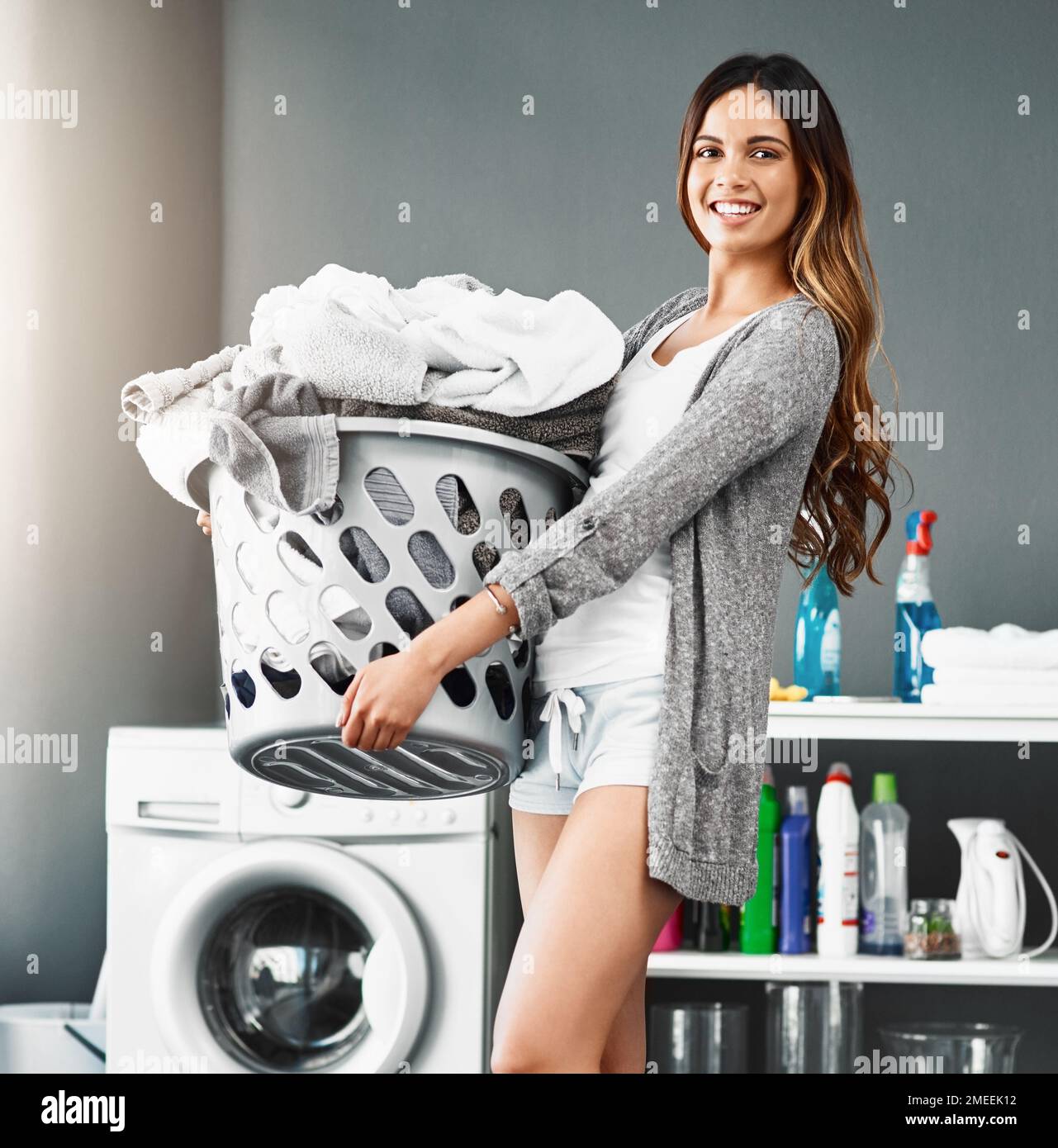 All ready and set for the next load. Cropped portrait of an attractive young woman doing her ...