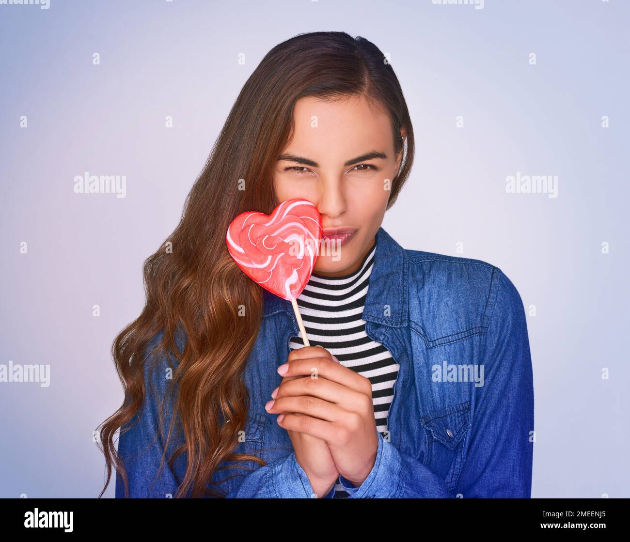 Her heart is as sweet as candy. Studio shot of a beautiful young woman ...