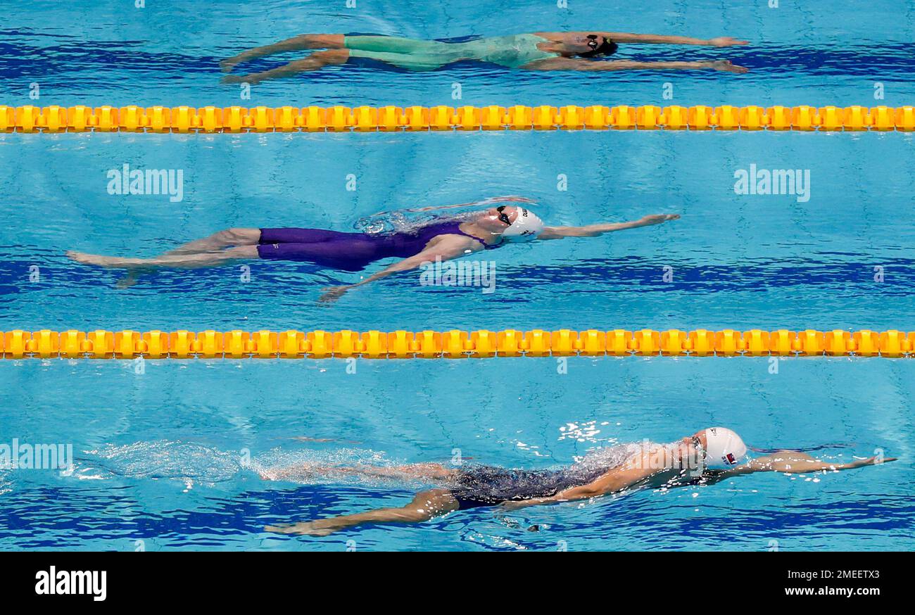 Athletes compete during the women's 200 meters backstroke preliminaries ...