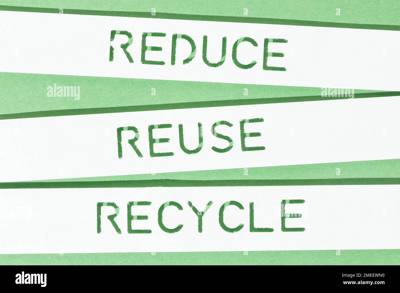 Reduce Reuse Recycle message on cut out paper strips on green ...