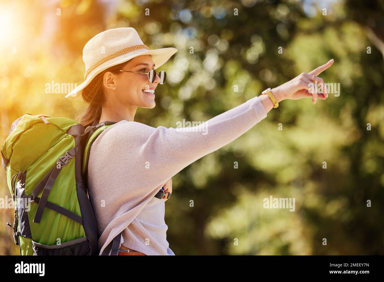 Happy woman, backpack or pointing in nature travel, sightseeing park or ...