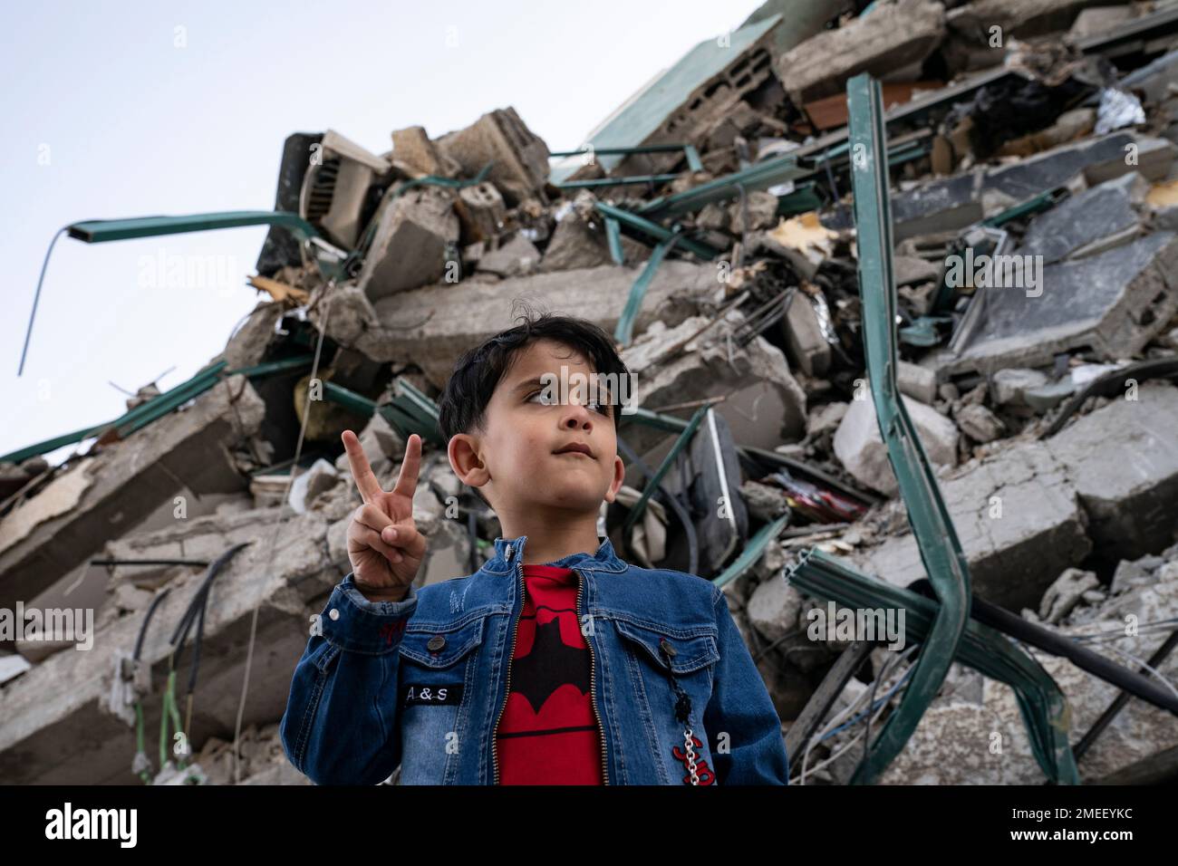 Spectators gather to view the rubble of the al-Jalaa building following ...