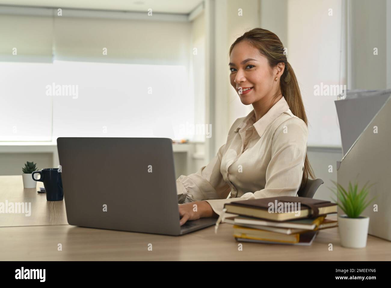 Confident female manager sitting front of laptop computer at her ...