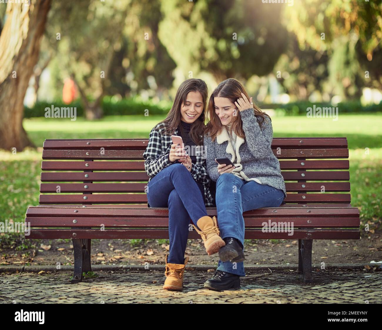 Two happy young women sitting hi-res stock photography and images - Alamy