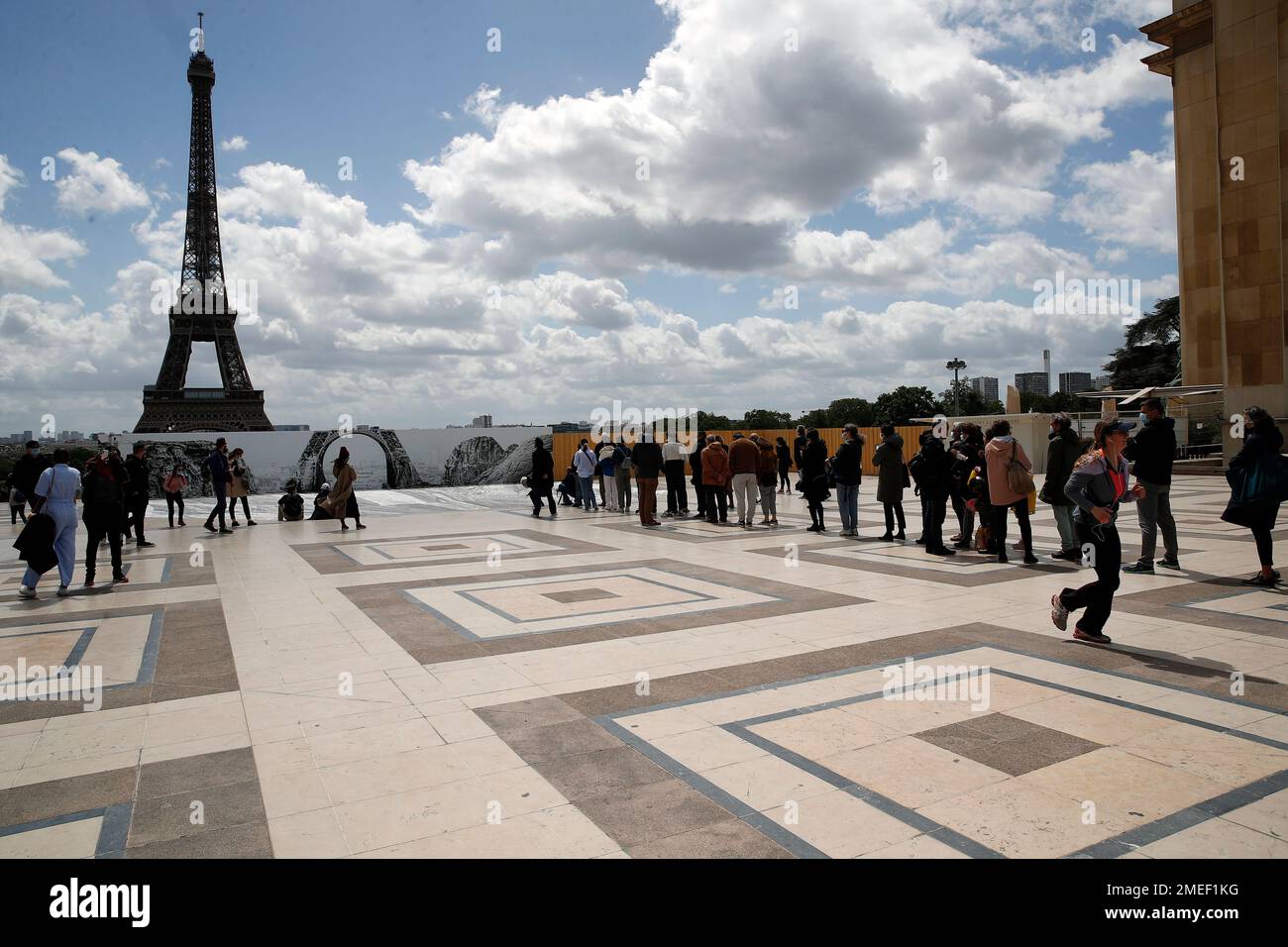 People queue on the Trocadero square in front of the Eiffel Tower to ...