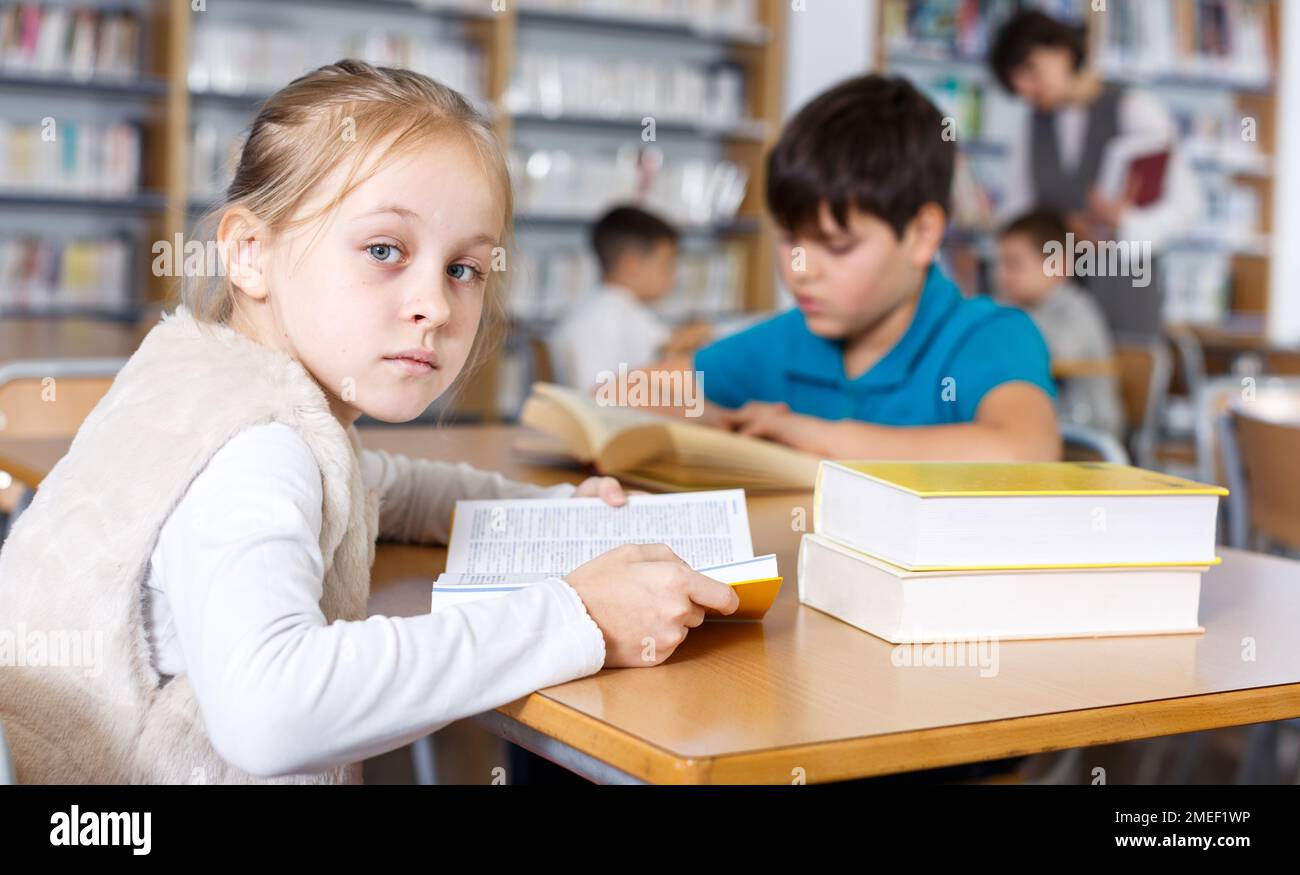 Tween girl in school library Stock Photo - Alamy