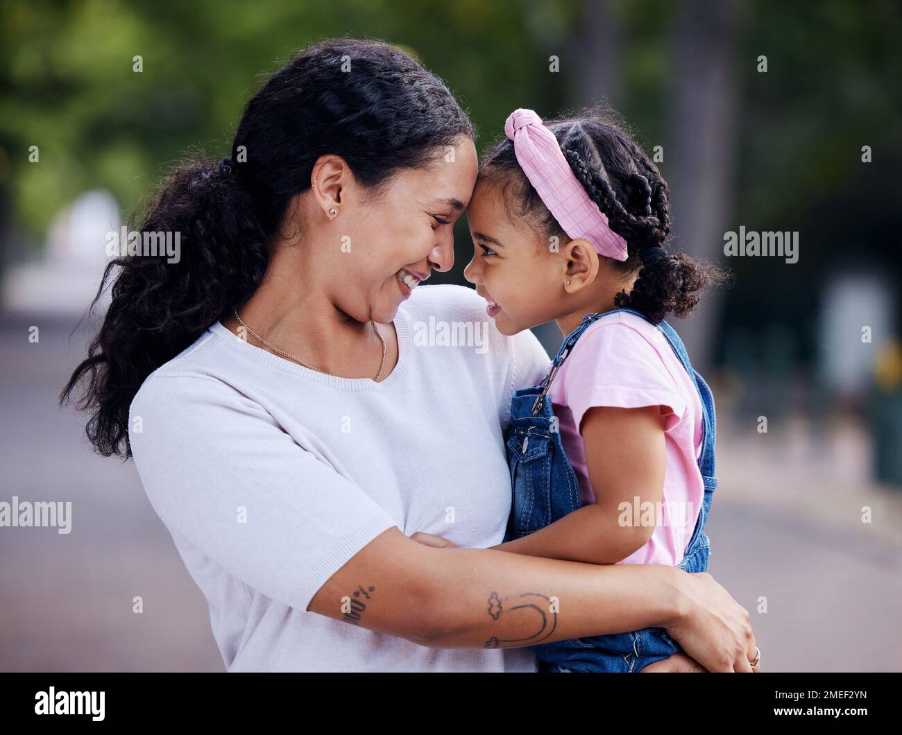 Love, family and mother carrying girl outdoors, bonding and hugging ...