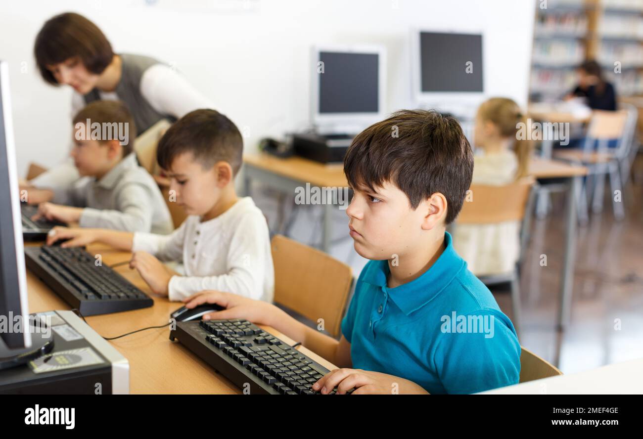 Tween boy during lesson in computer room Stock Photo - Alamy