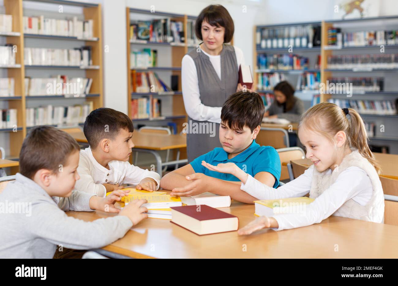 School kids studying with female teacher Stock Photo - Alamy