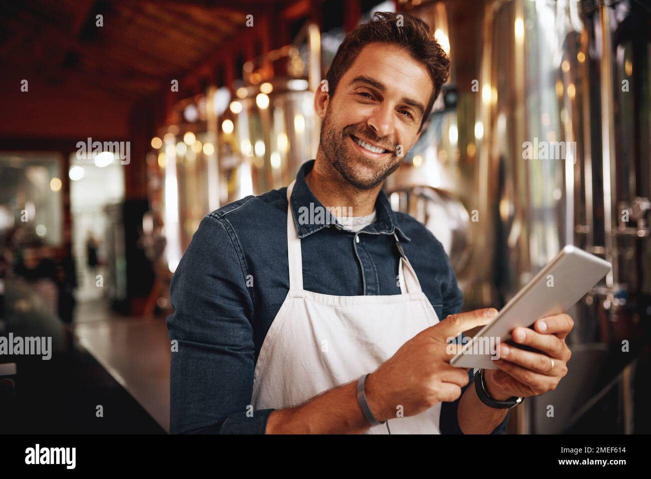 Business is going great like usual. Portrait of a cheerful young barman ...