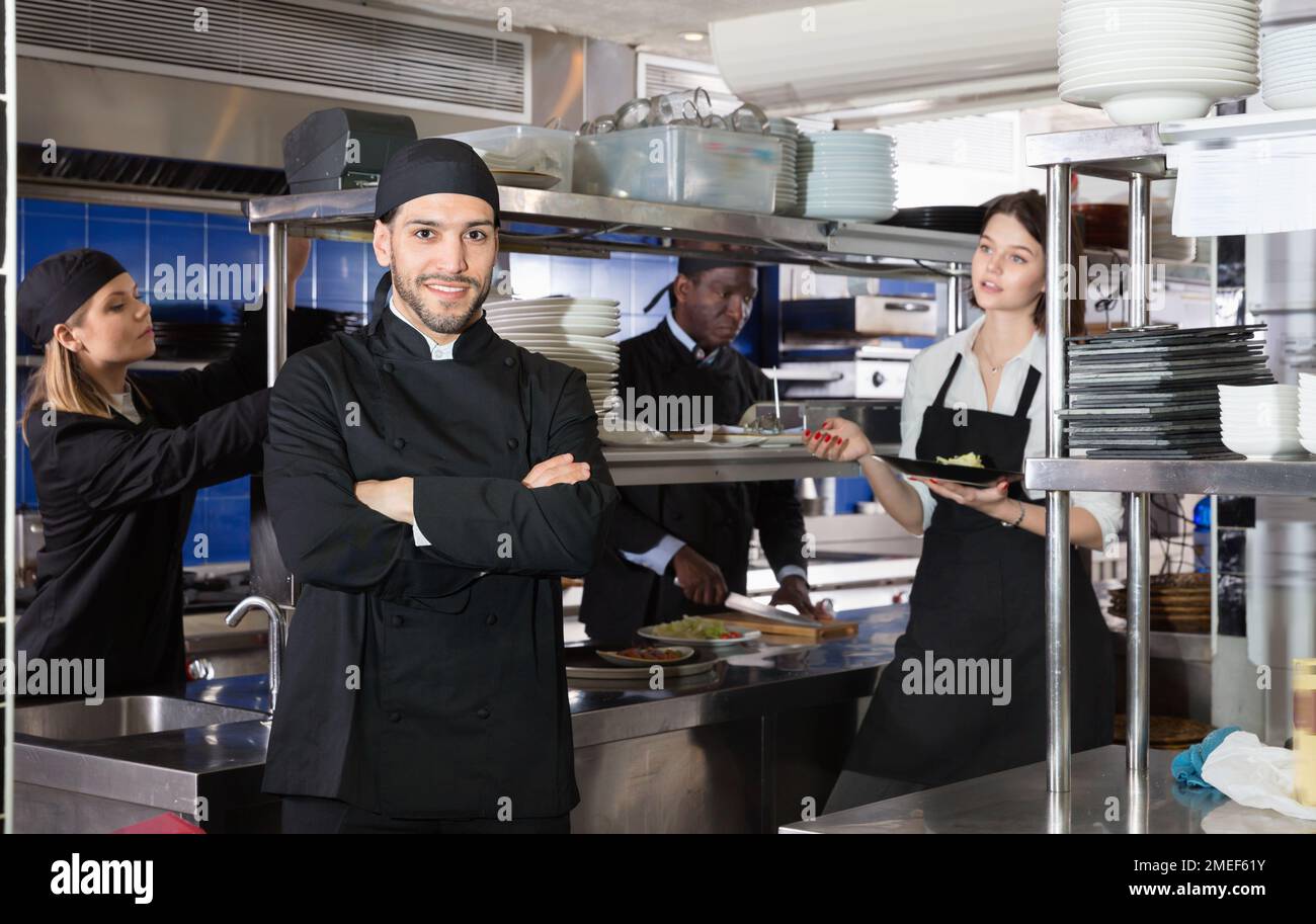 Smiling chef cook is posing on kitchen in restaurant Stock Photo - Alamy