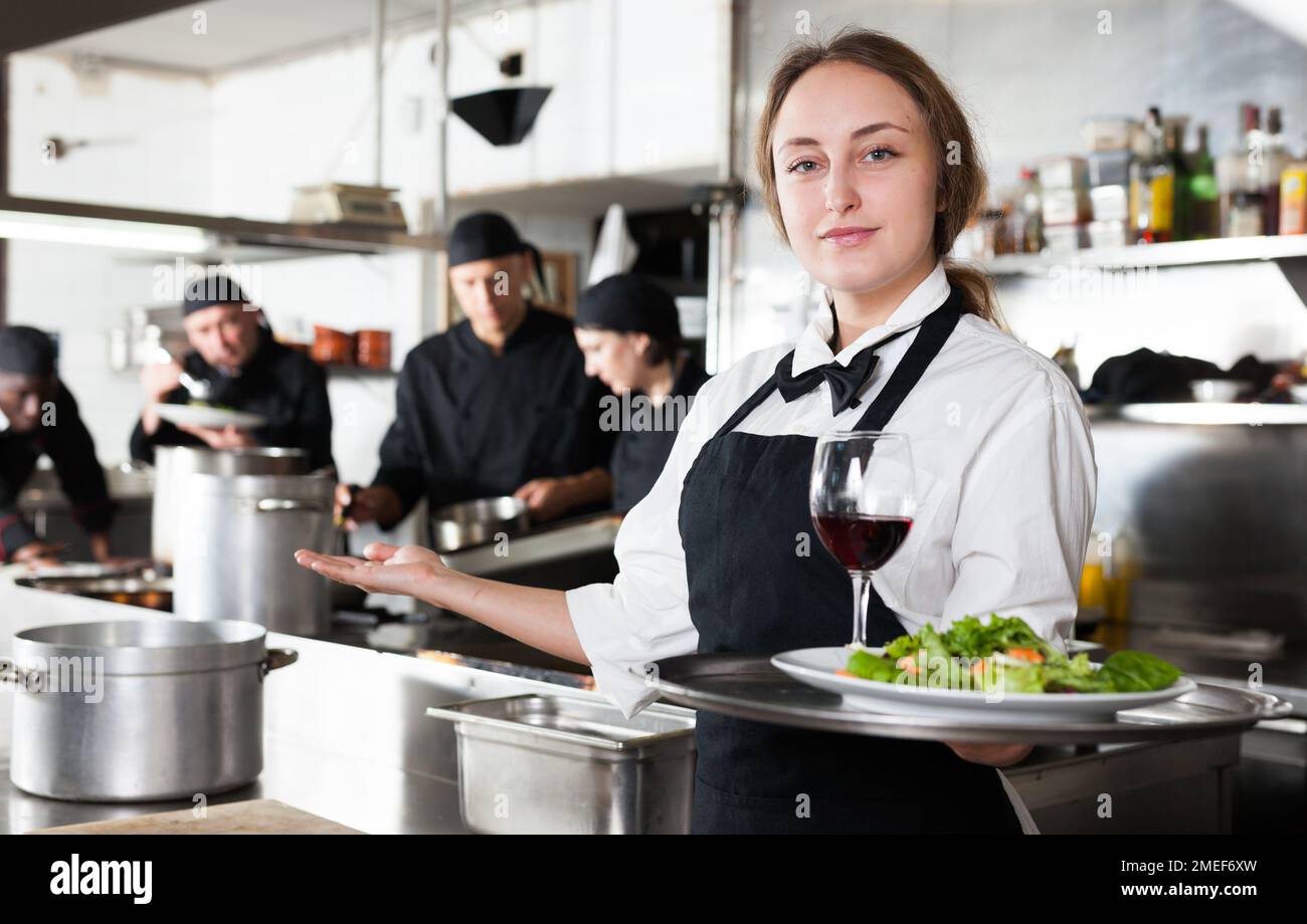 Professional waitress holding serving tray at restaurant kitchen Stock ...