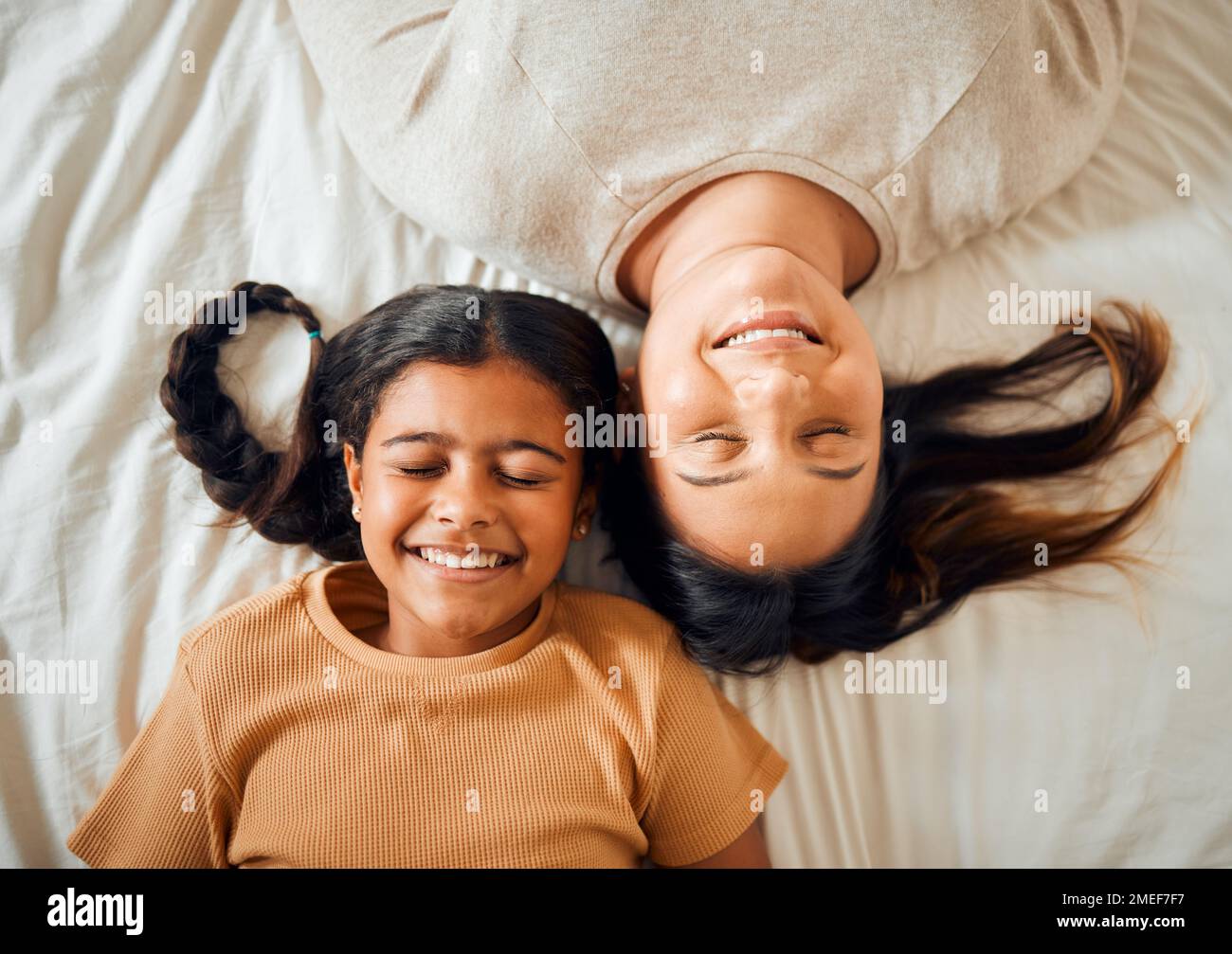 Family, happy and mother and daughter from above in bed, relax and ...