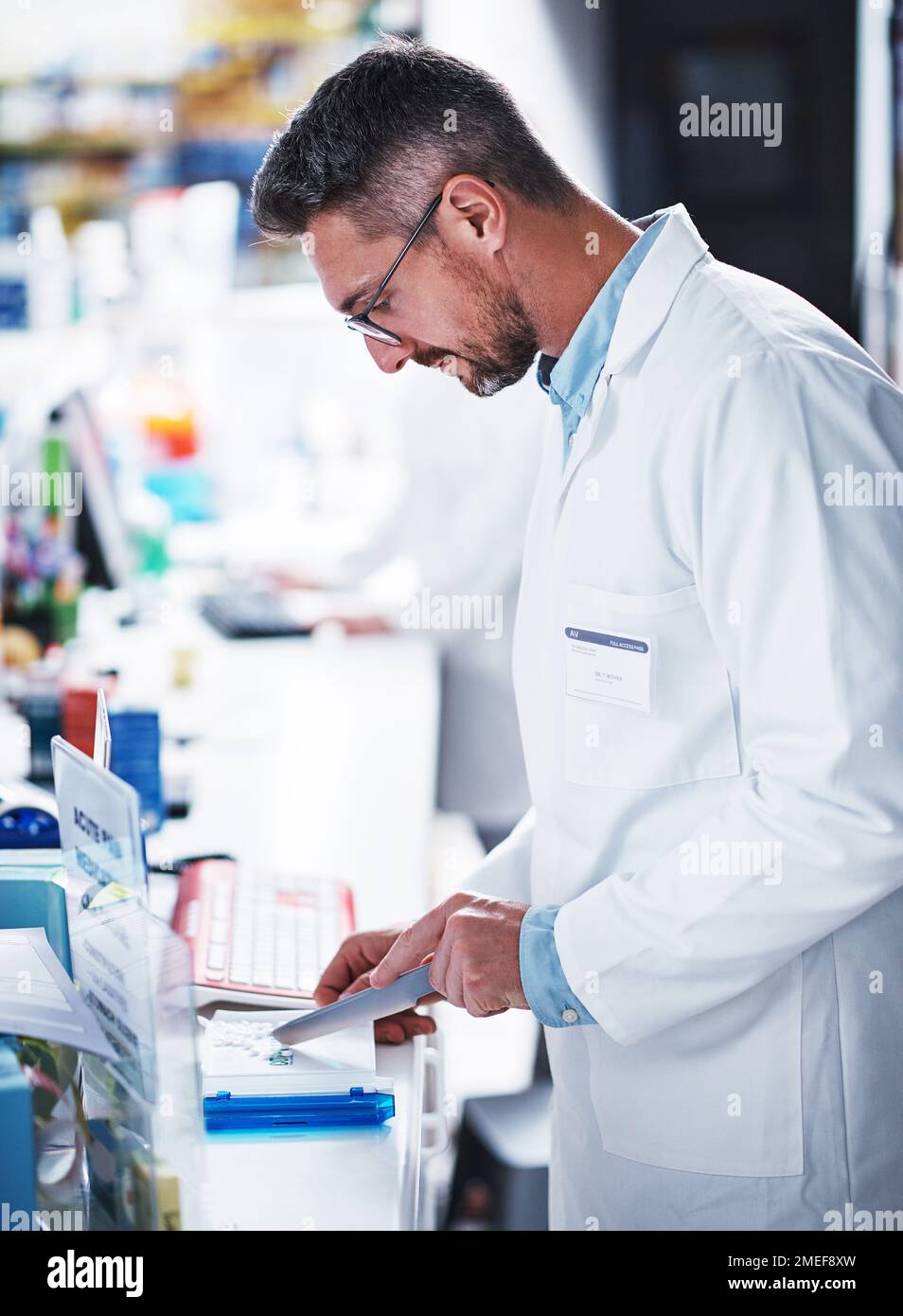 Sorting and processing different pills. a mature pharmacist sorting ...
