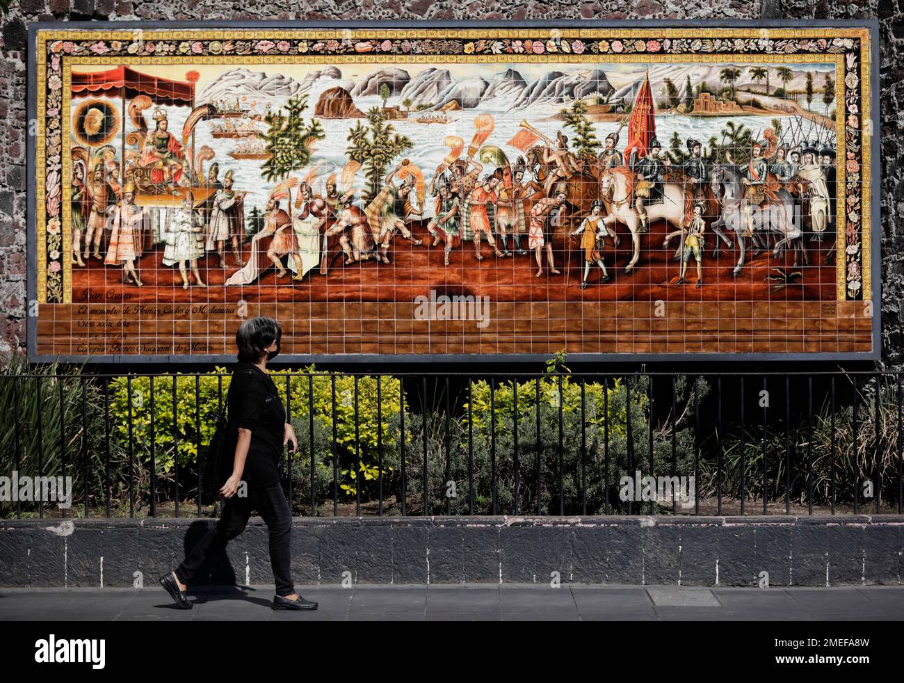 A woman walks past a mural commemorating the meeting of the Spanish ...