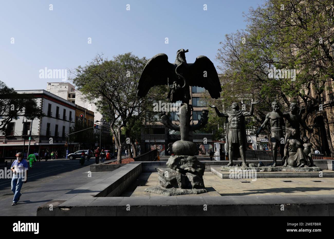 A man walks past statues representing the foundation of Tenochtitlan ...