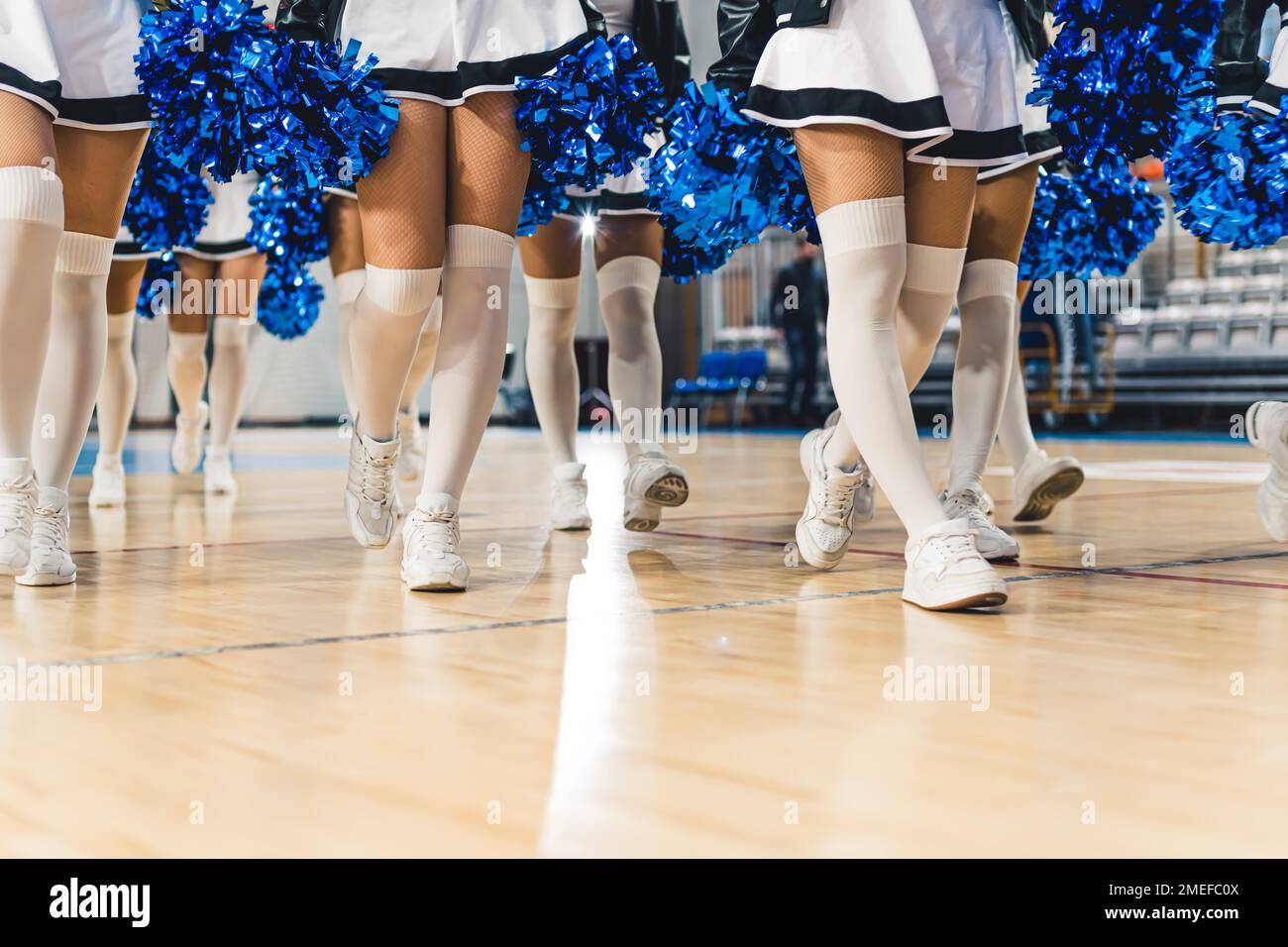 Legs of female cheerleaders dressed in white dresses and white high ...