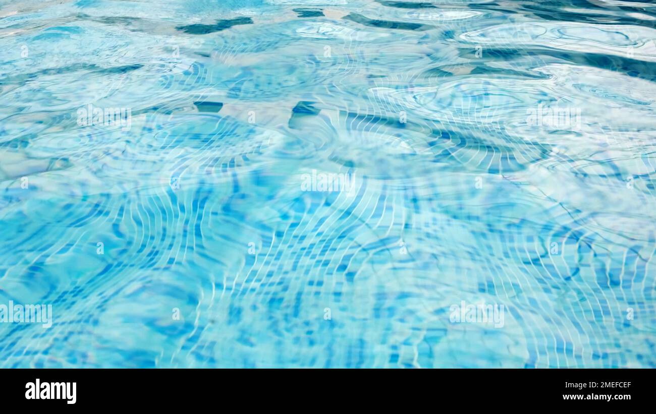Clear blue waves on the surface of the swimming pool background. The ...