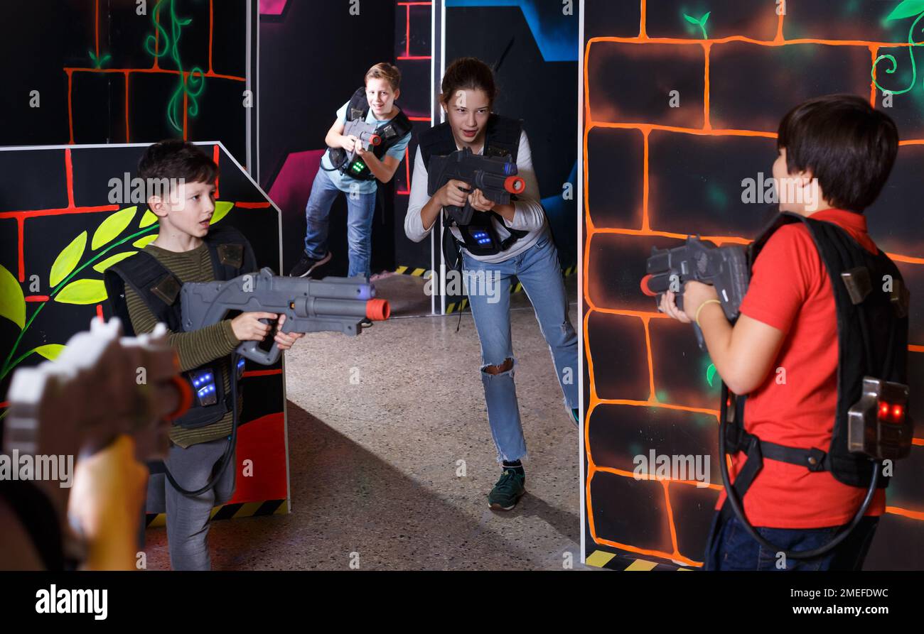 Cheery kids aiming laser guns at other players Stock Photo - Alamy