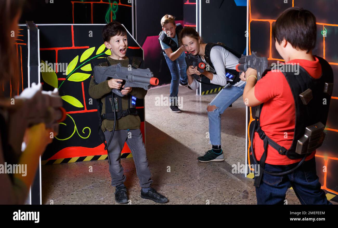 Merry kids aiming laser guns at other players Stock Photo - Alamy
