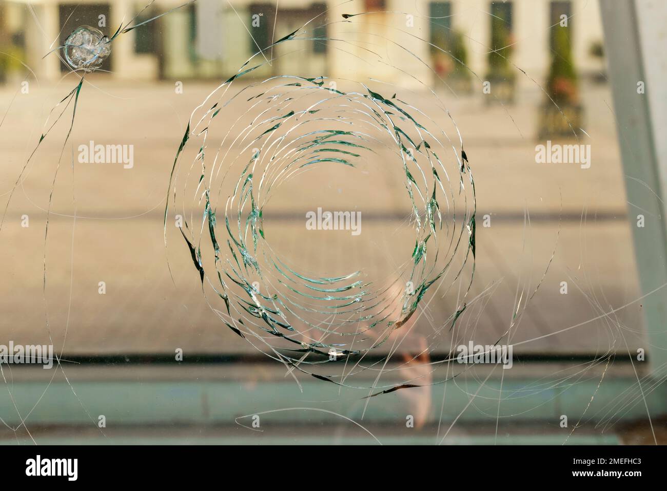 Broken glass with a hole and cracks on the street Stock Photo - Alamy