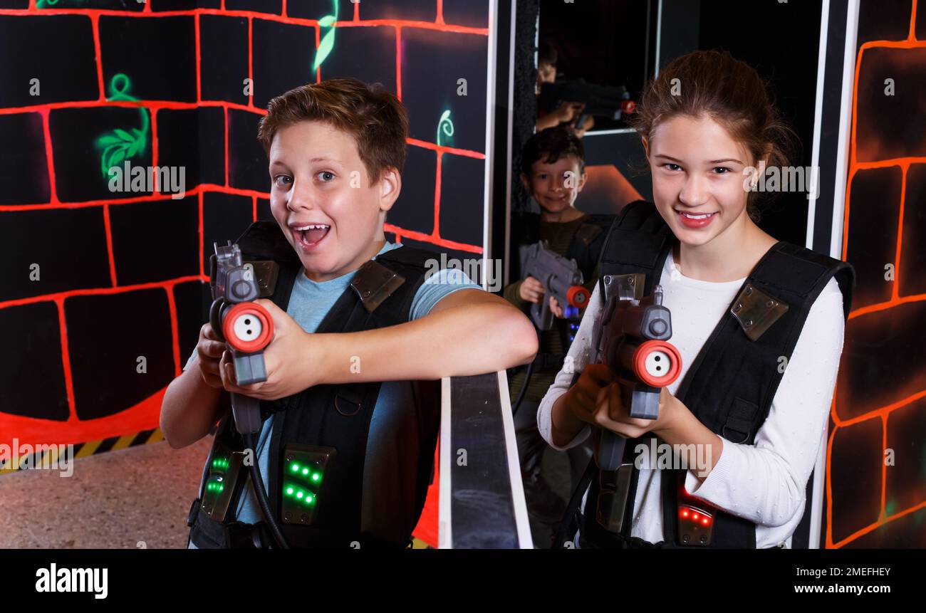 Girl and boy playing laser tag Stock Photo - Alamy