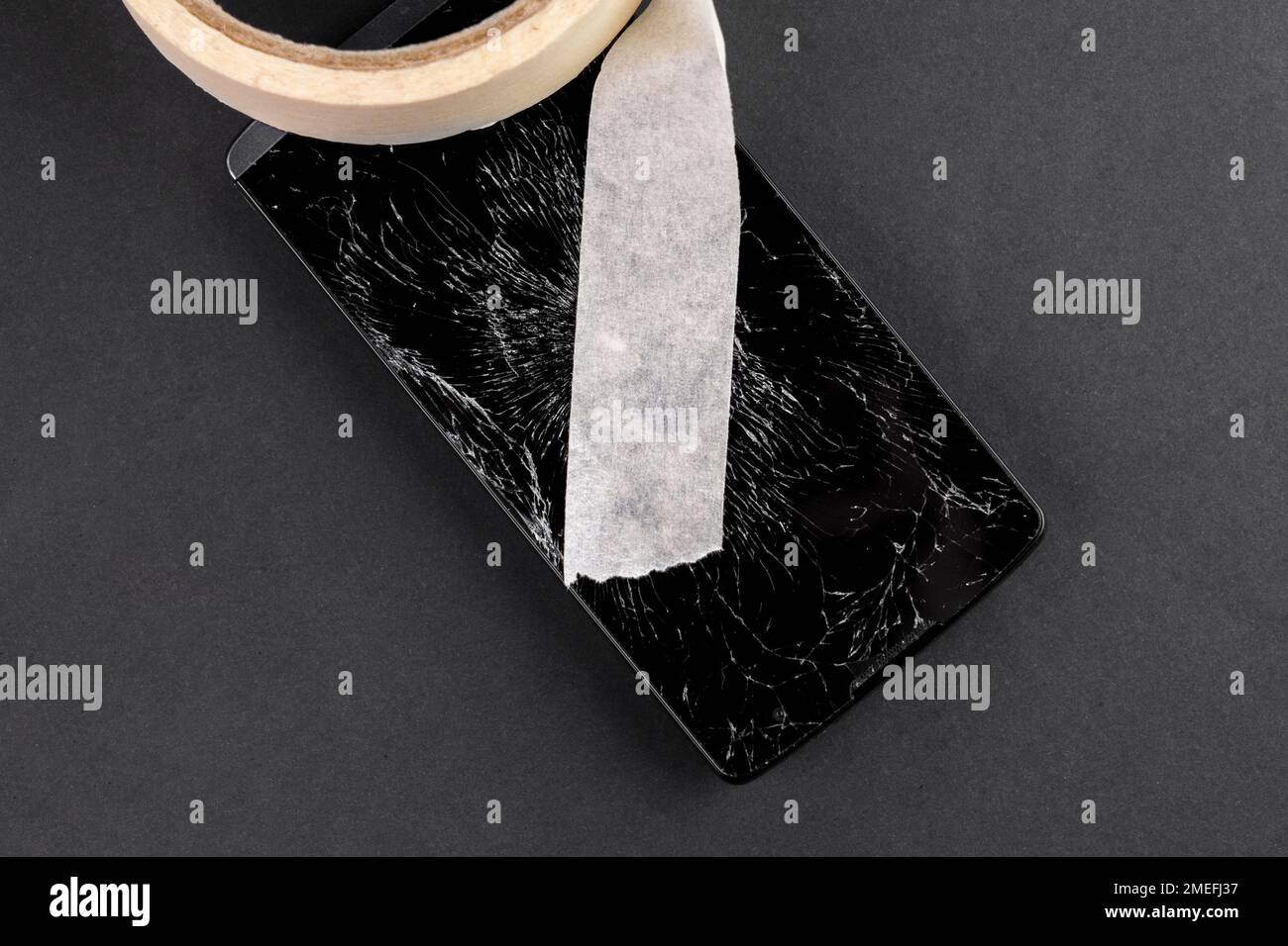 Broken black mobile phone with shattered glass screen covered with ...