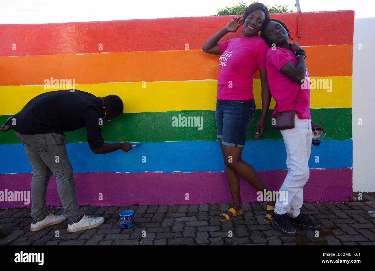 Members of the LGBT pose for a photo after painting a wall with colours ...