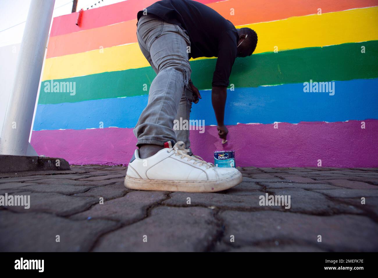 Members of the LGBT community are seen painting a wall with colours of ...