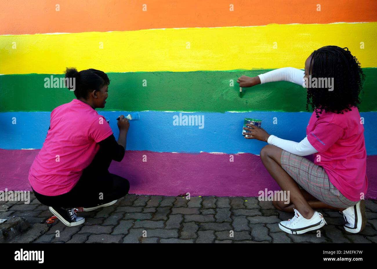 Members of the LGBT community are seen painting a wall with colours of ...