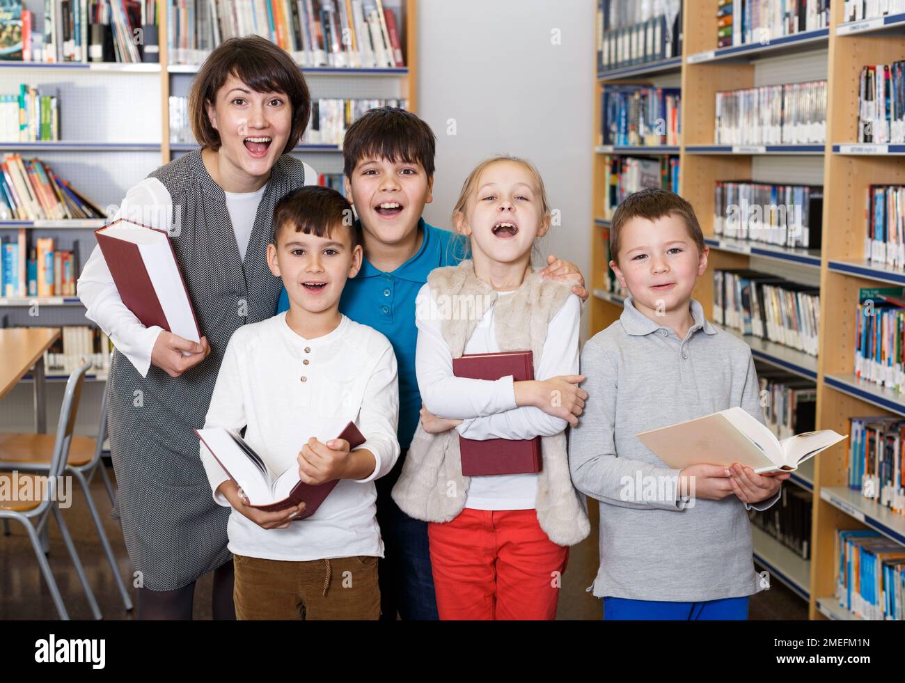 Smiling pupils with female teacher in classroom Stock Photo - Alamy