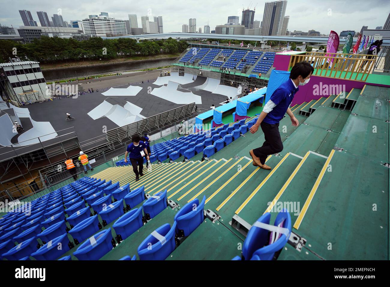 Staffs walk at the grand stand as athletes compete during the Tokyo ...