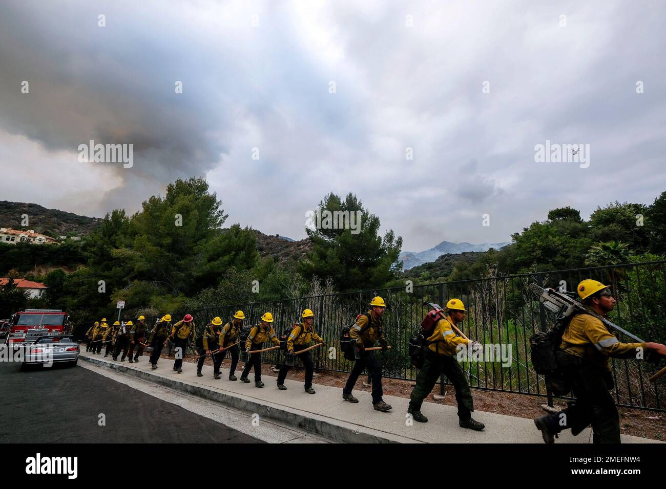 Members of the Hotshots fire crew walk in line during a wildfire in the ...