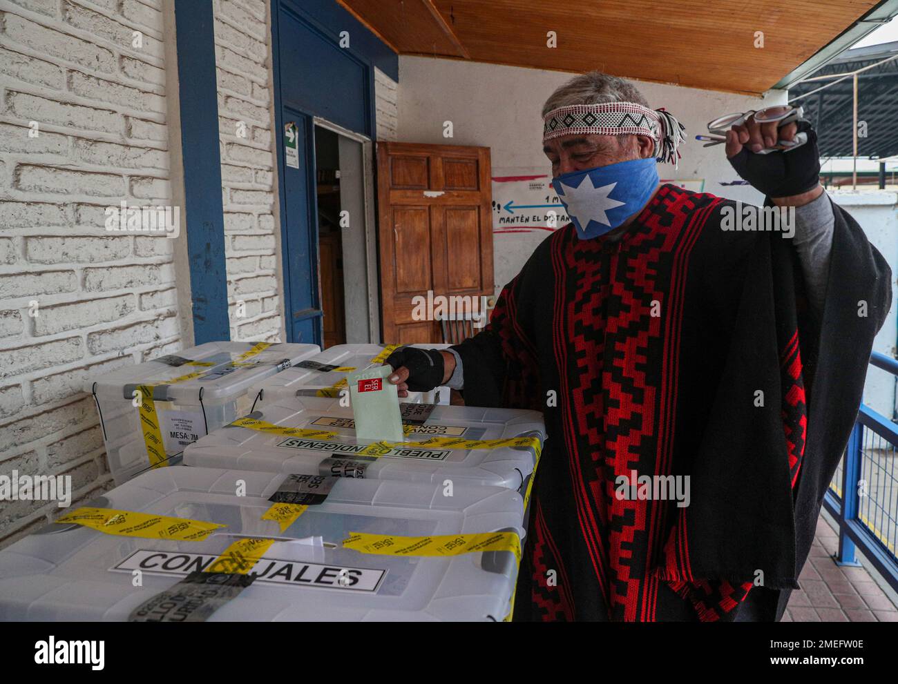 A Mapuche Indigenous man known as Clay casts his ballot at a polling ...