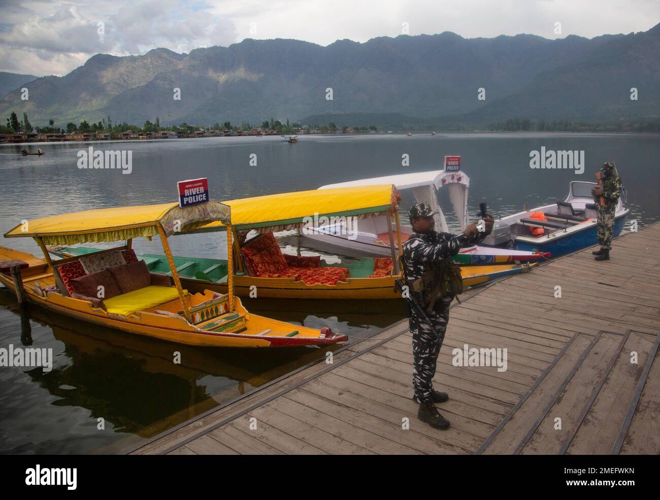 An Indian paramilitary soldier takes a selfie on the banks of Dal lake ...