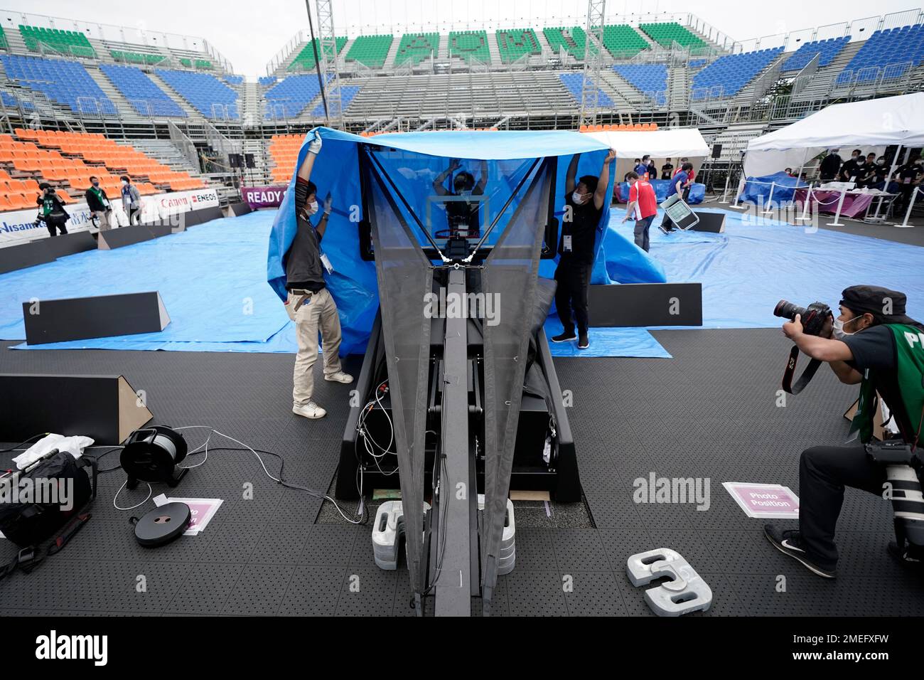 Staff cover the basketball goal post as the rain starts during the ...