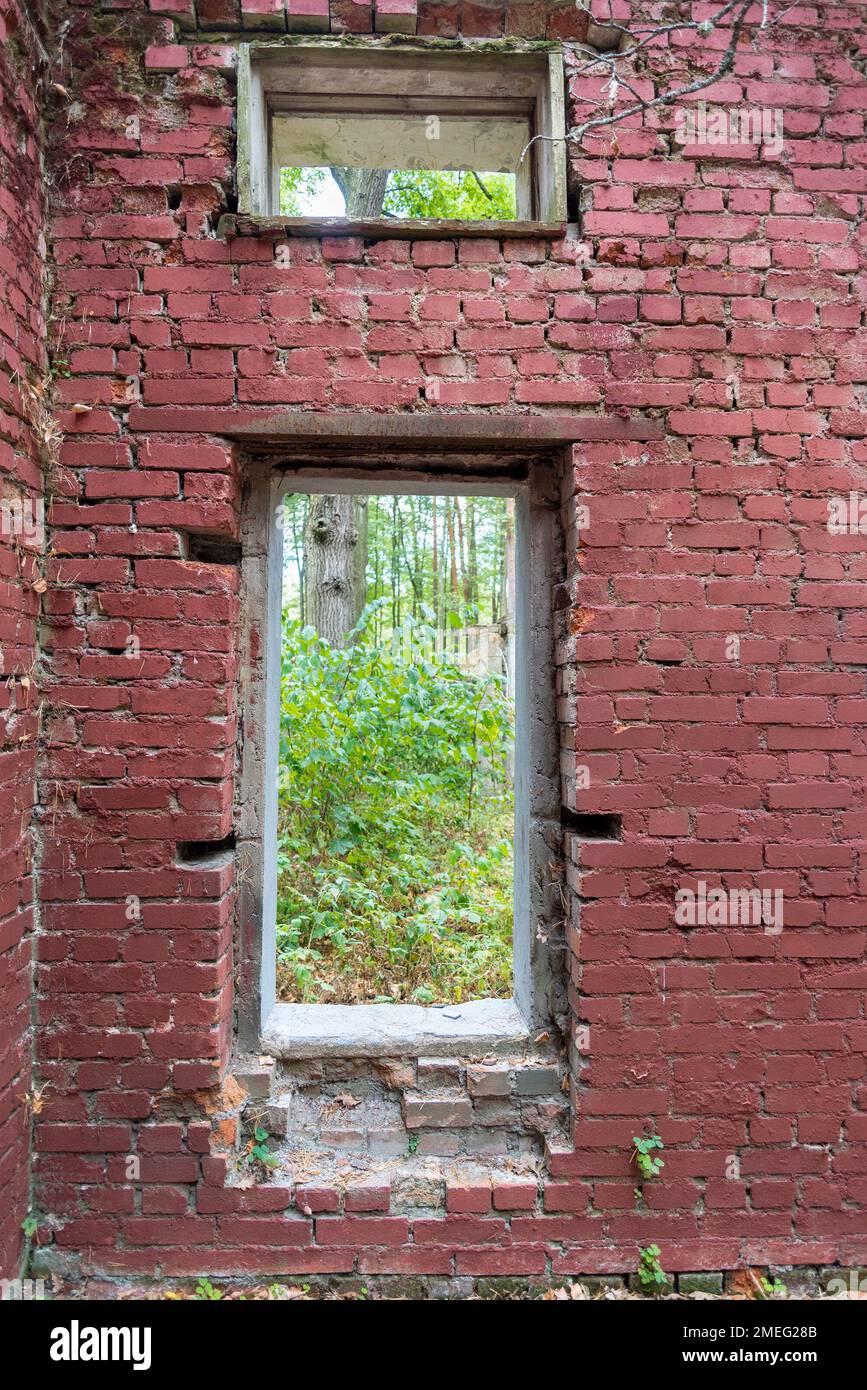 A brick opening without a window of an old and destroyed building. An ...