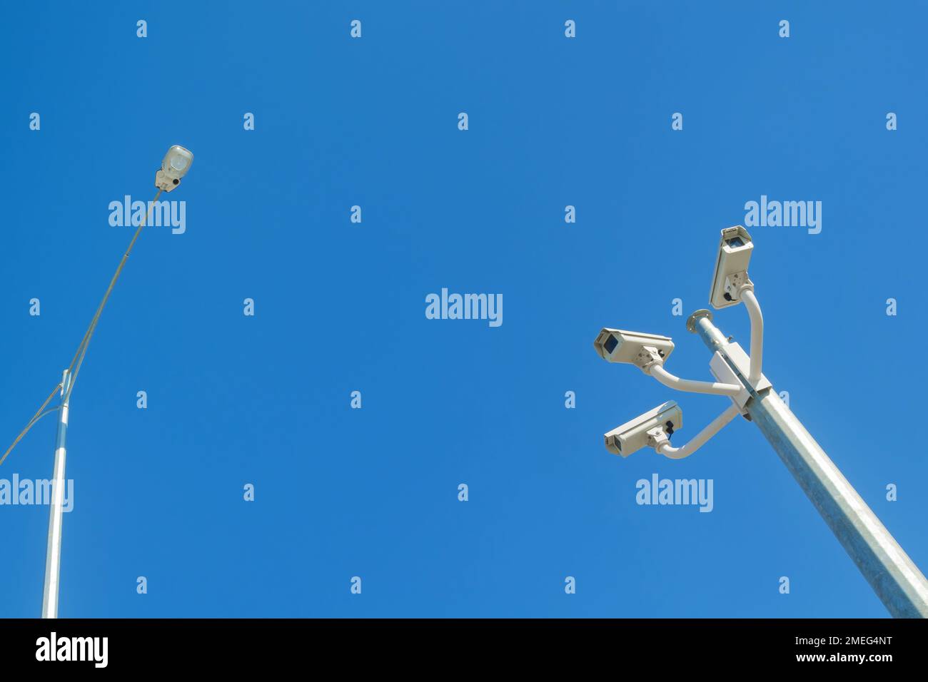Security CCTV cameras and streetlight against blue sky Stock Photo - Alamy