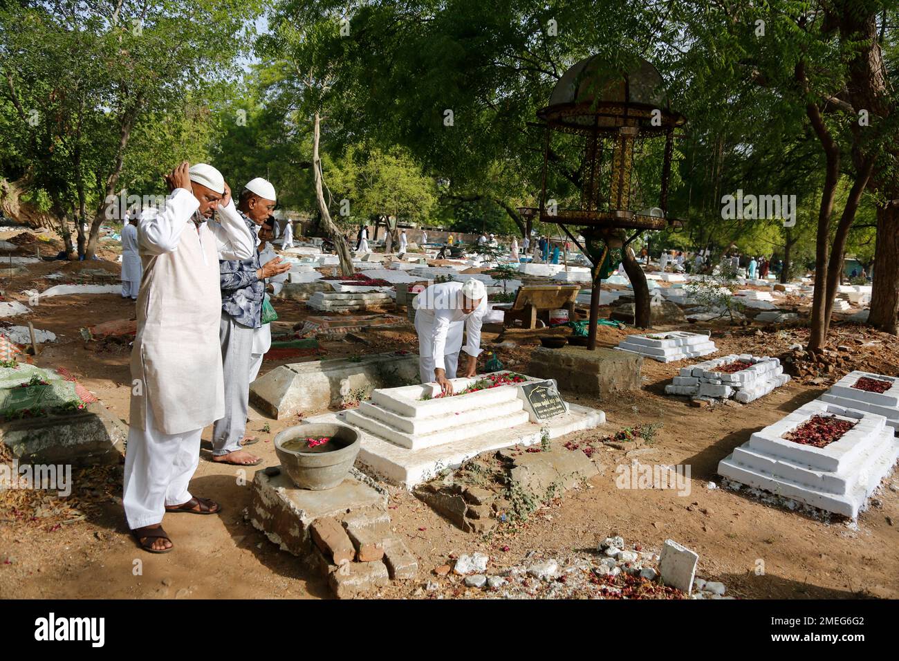 Indian Muslim men offer prayers near the grave of their relatives on ...