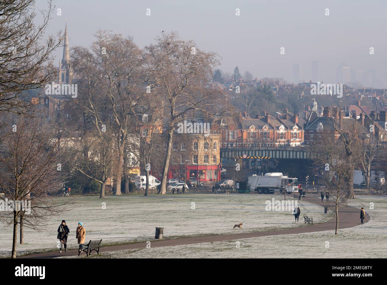 Park users walk through Brockwell Park on a cold January winter morning ...