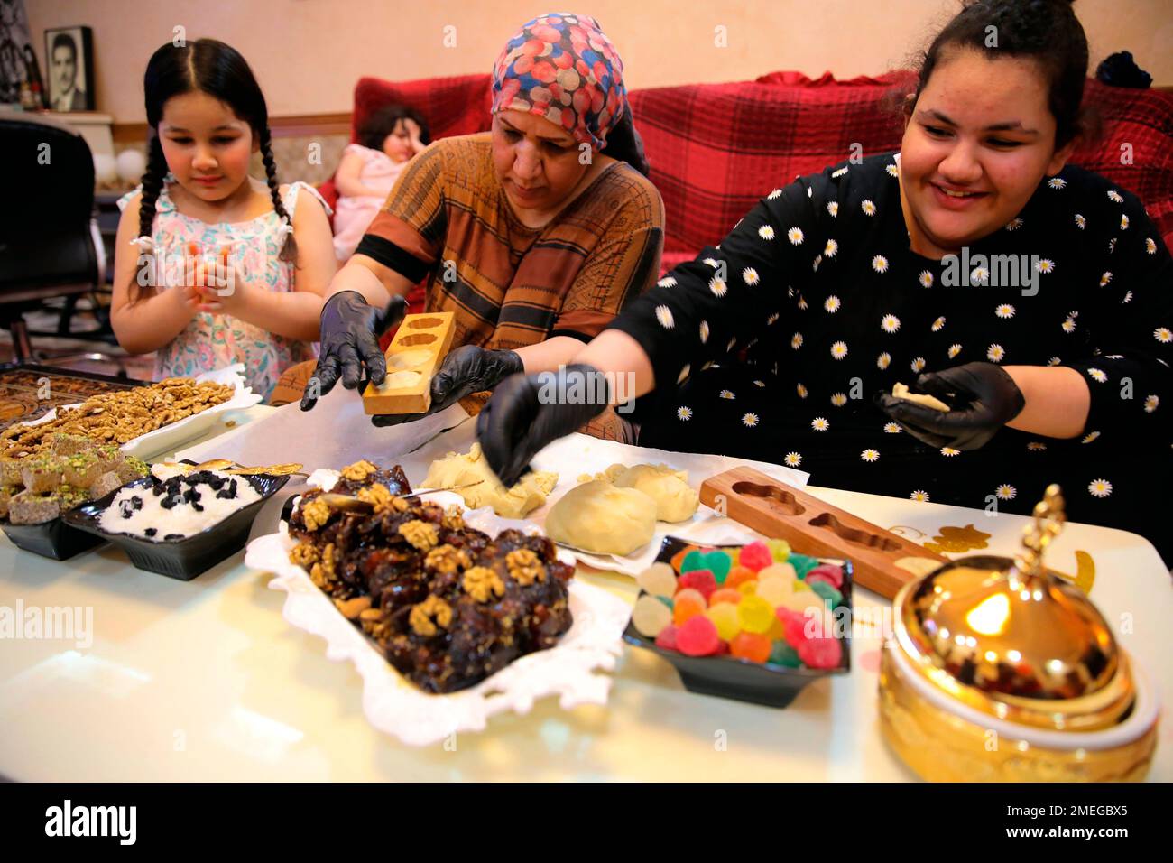 A family prepares cookies during the first day of Eid al-Fitr holiday ...