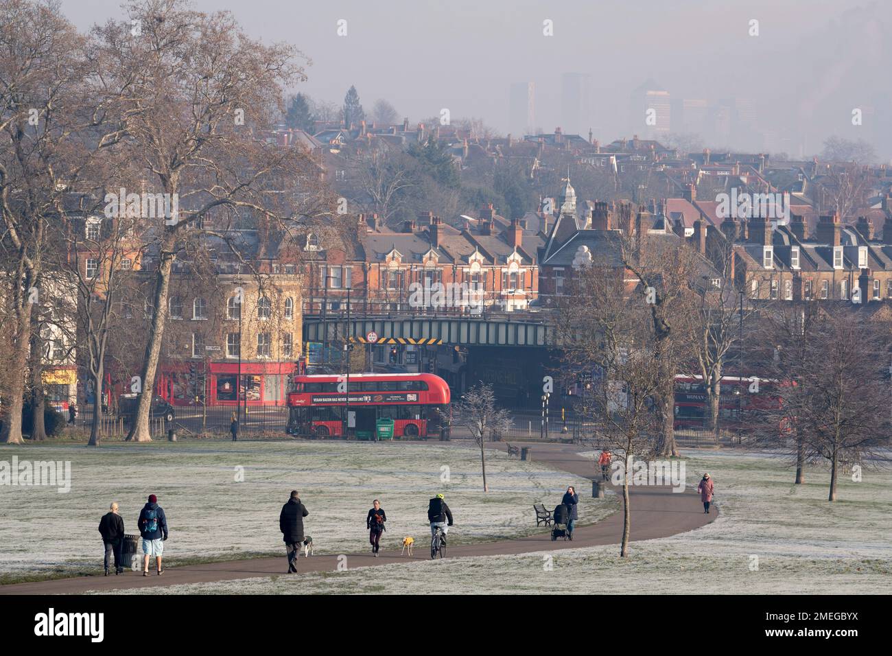 Park users walk through Brockwell Park on a cold January winter morning ...