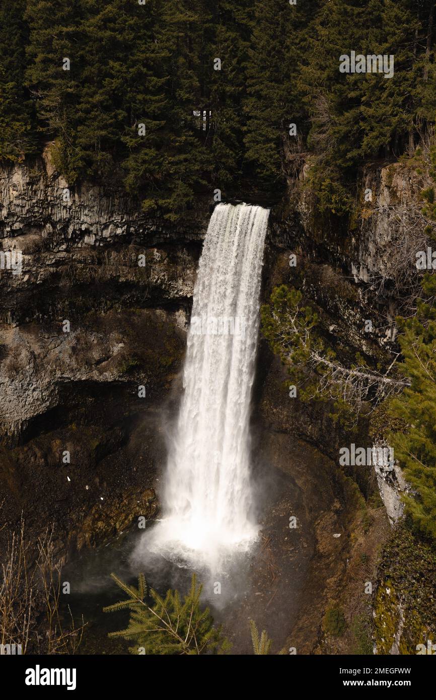A vertical aerial view of foamy waterfall flowing down the steep rocky ...