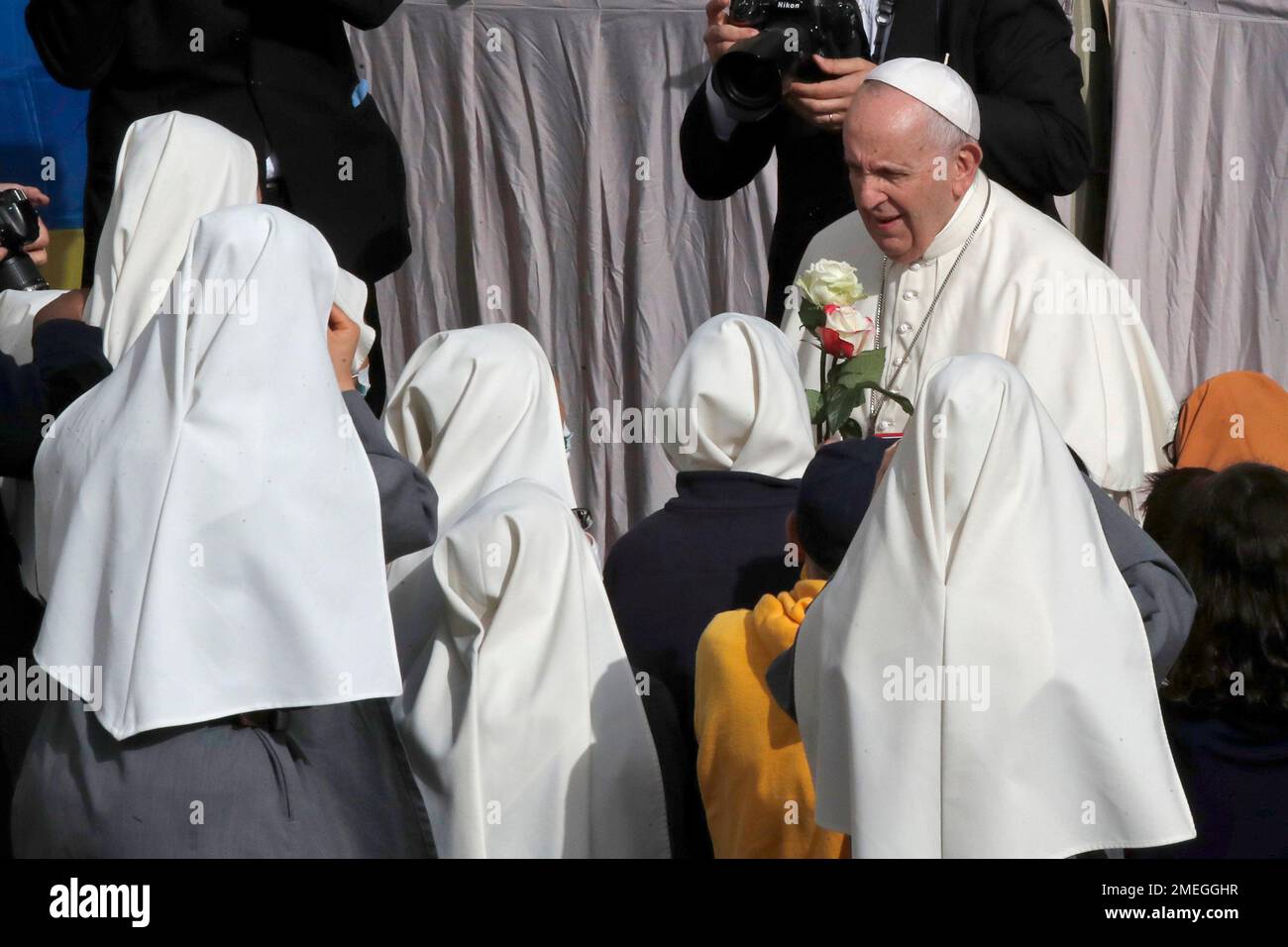 Nuns hand a rose to Pope Francis as he arrives in the St. Damaso ...